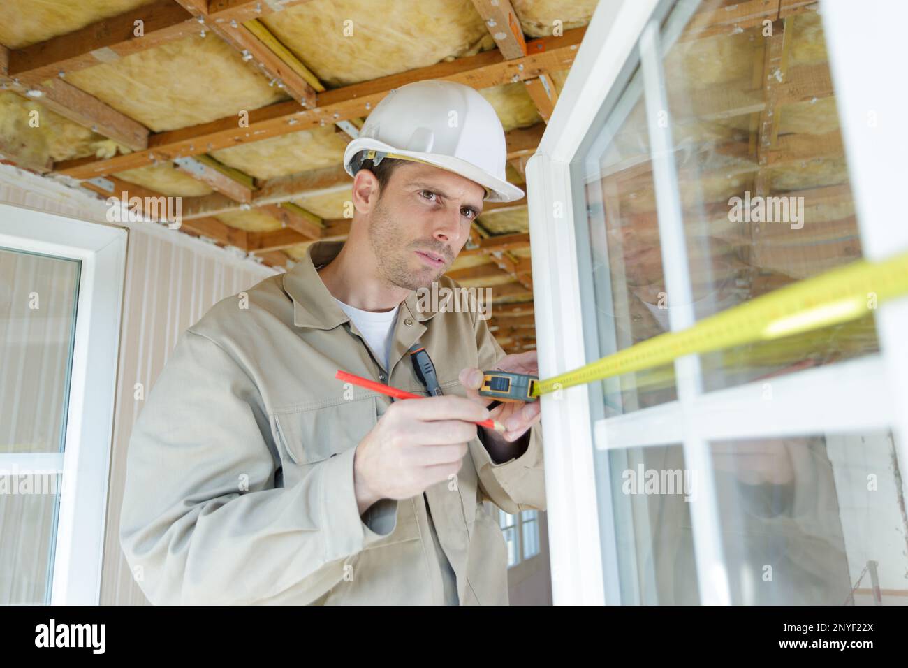 a workman measuring a window Stock Photo - Alamy