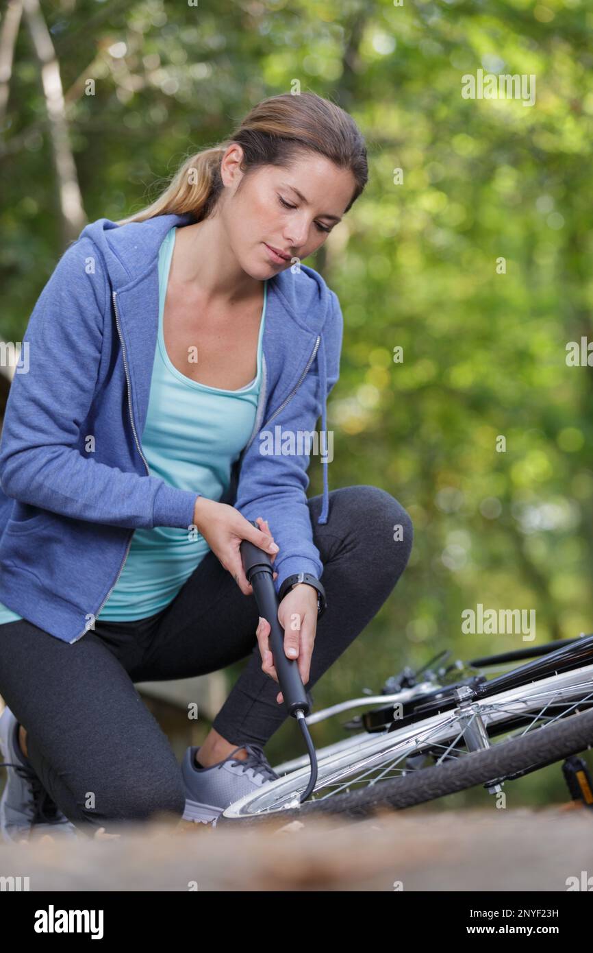 woman pumping her bike up Stock Photo - Alamy