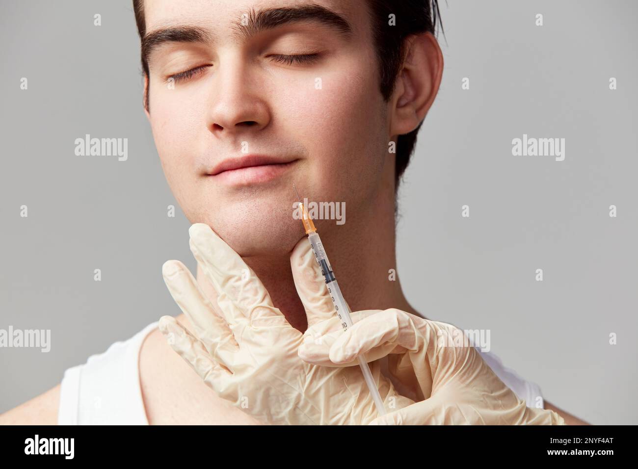 Face rejuvenation. Portrait of young man doing cosmetological ...