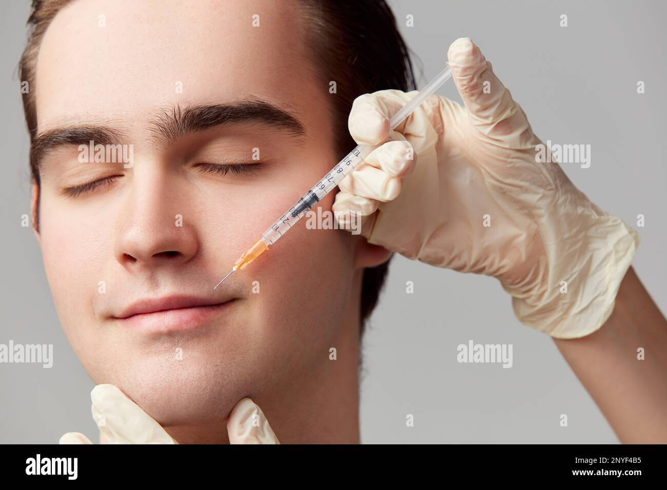 Lip augmentation. Close-up of young man doing beauty cosmetological ...