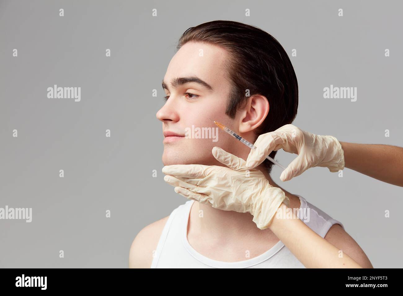 Fillers in cheeks. Portrait of young man doing cosmetological ...