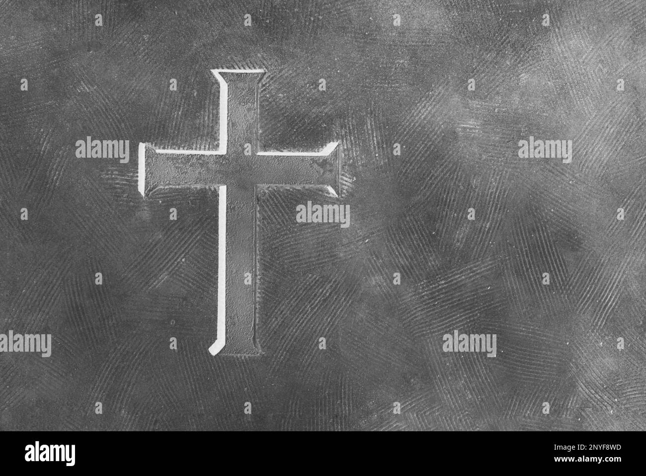 A simple plain cross etched into a natural copper metal wall in a black ...