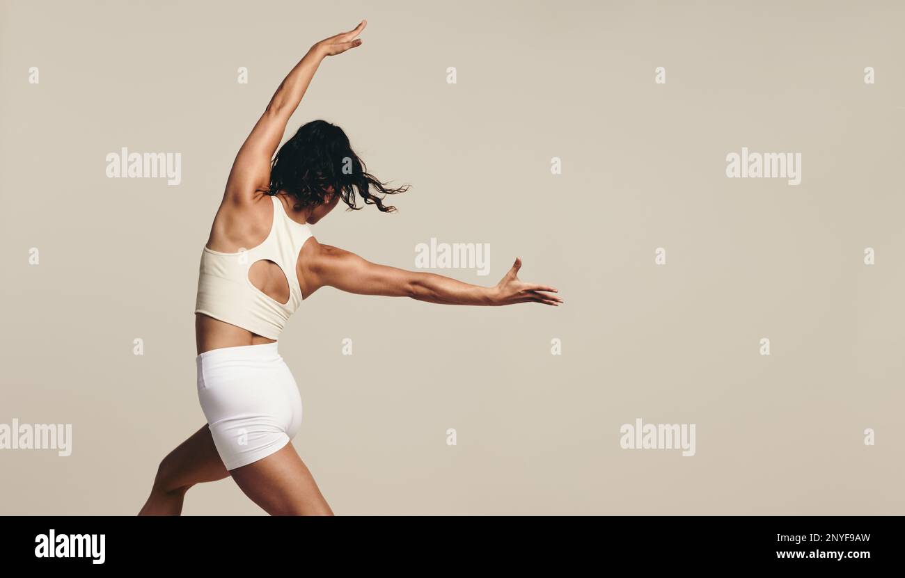 Female athlete in sports clothing doing stretching exercises in a ...