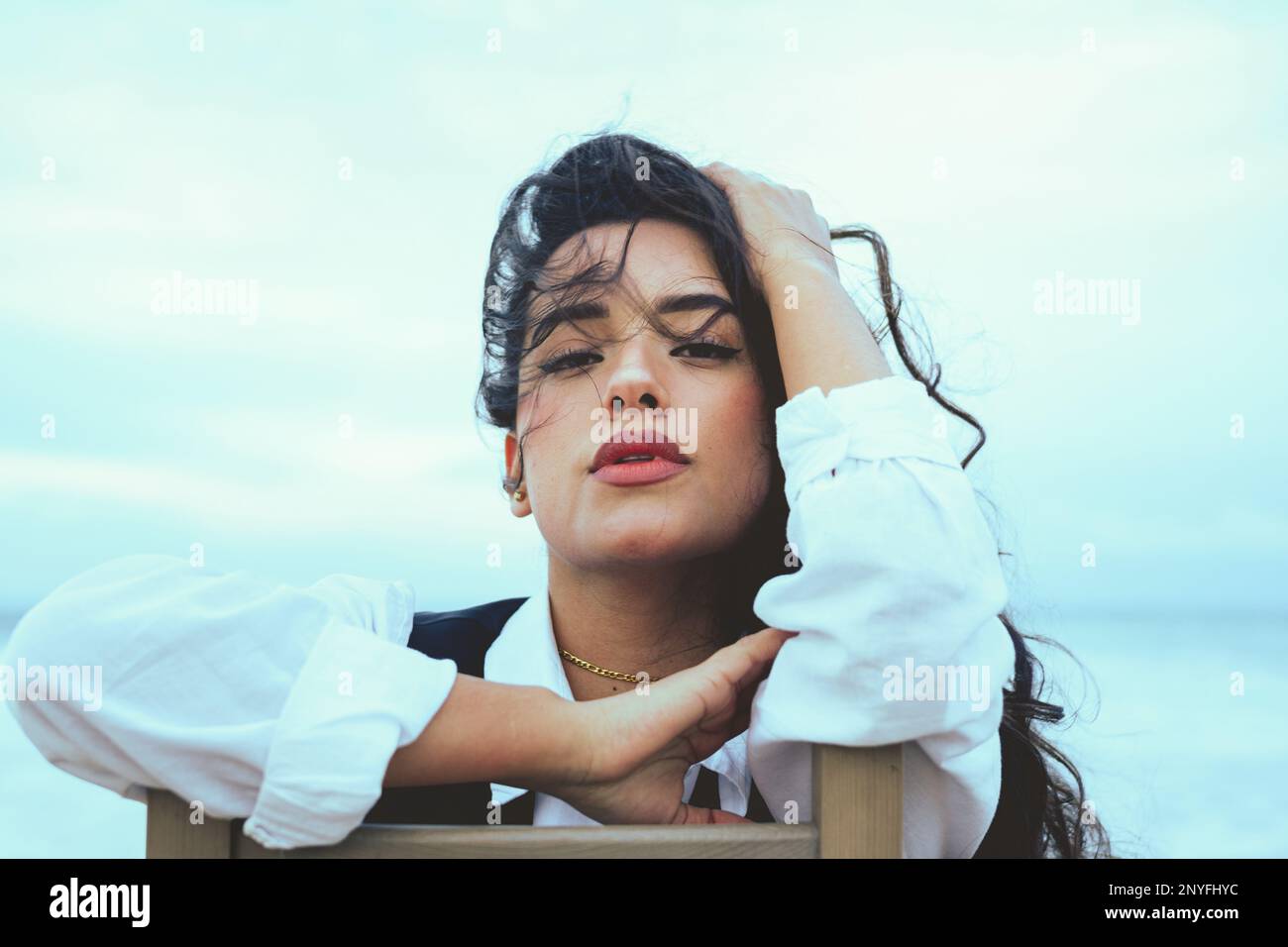 Portrait of a young woman leaning against chair hi-res stock ...