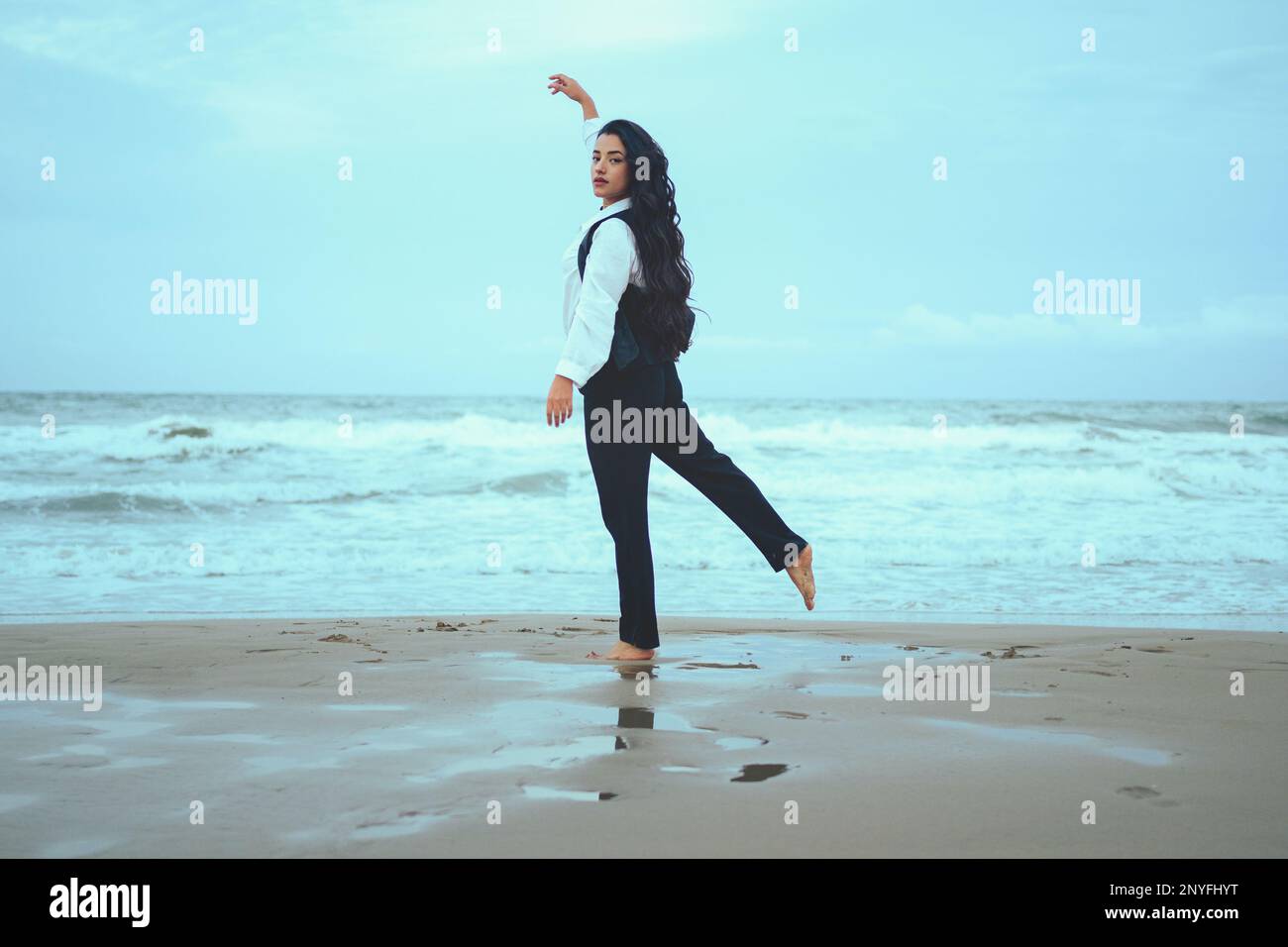 Full body back view of barefoot female in classy outfit balancing on ...