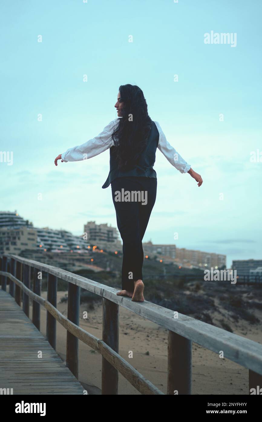 Full body back view of unrecognizable female in classy outfit balancing ...