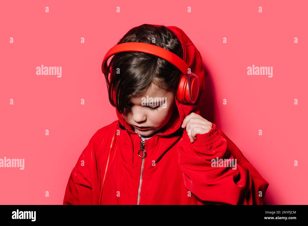 Confident bored young girl in headset wearing casual oversize hooded ...