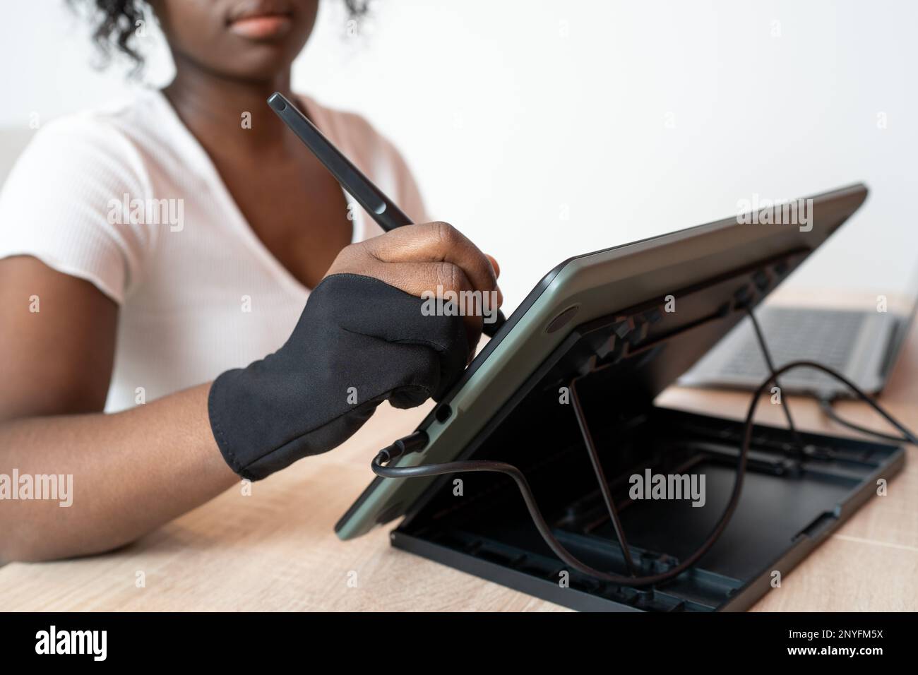 Side view unrecognizable African American female in glove using stylus ...