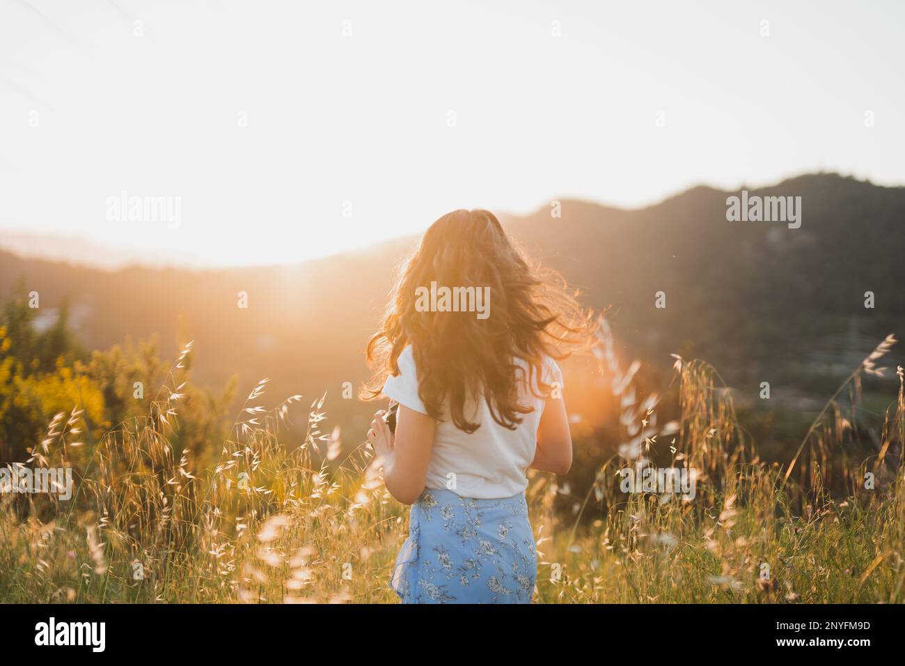 Back view of unrecognizable female photographer in casual summer ...