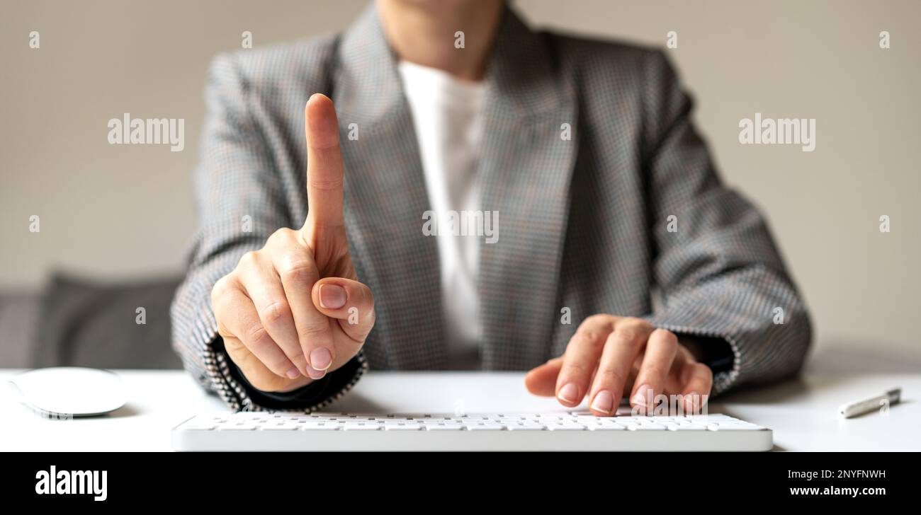 Female person sitting at the desk working on computer touching virtual ...