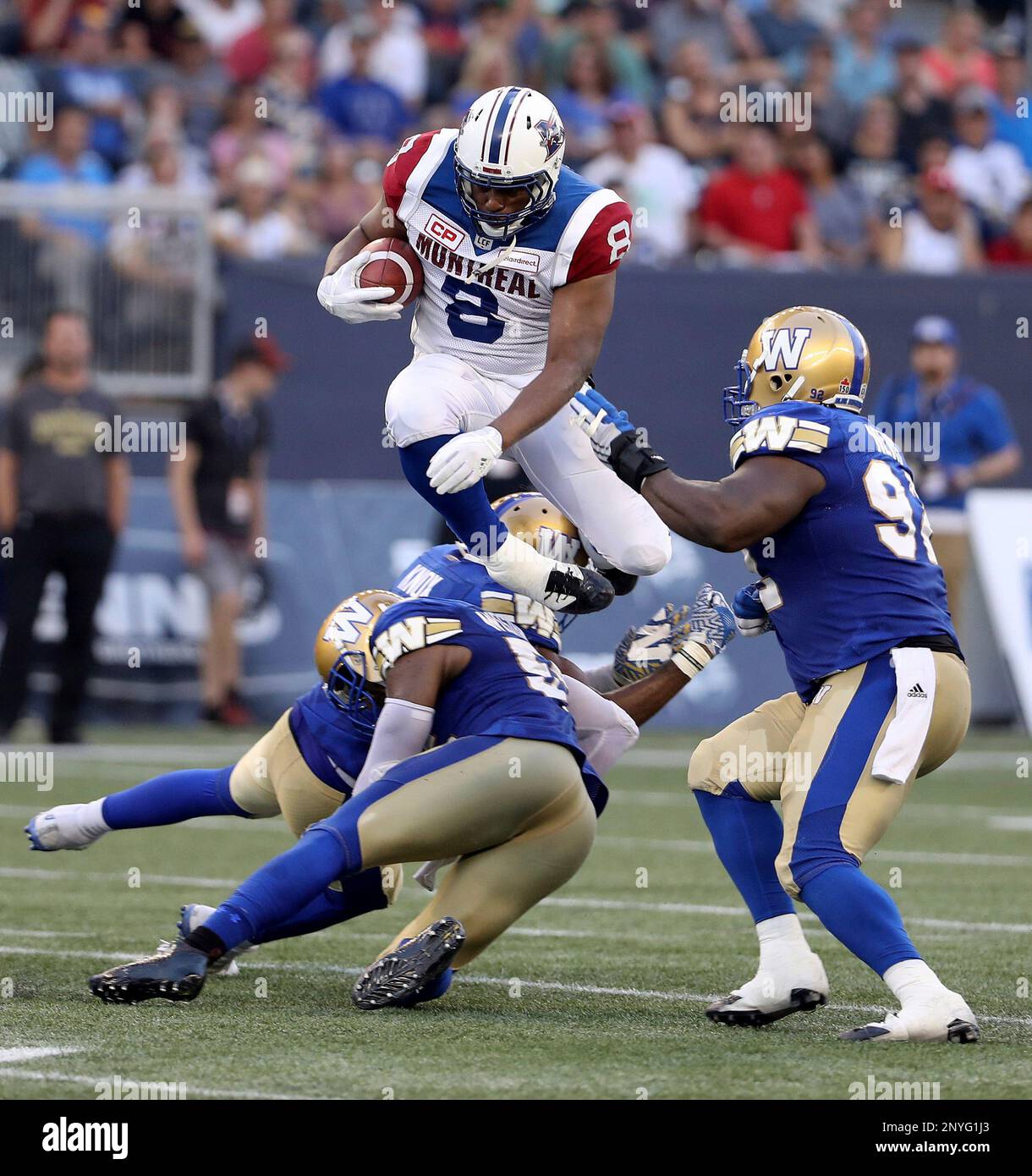 Montreal Alouettes slotback Nik Lewis (8) hurdles Winnipeg Blue Bombers ...