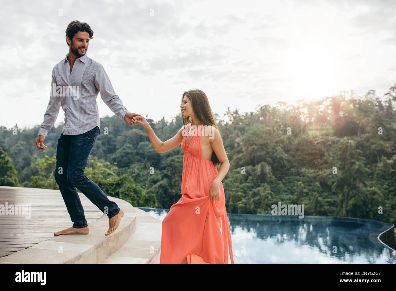 Portrait of young couple near swimming pool. Young man and woman ...