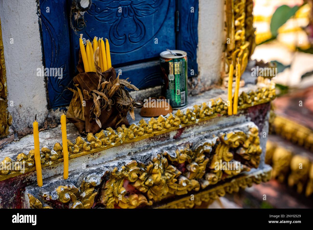 An ornately decorated shrine with gold accents with a soda can and ...