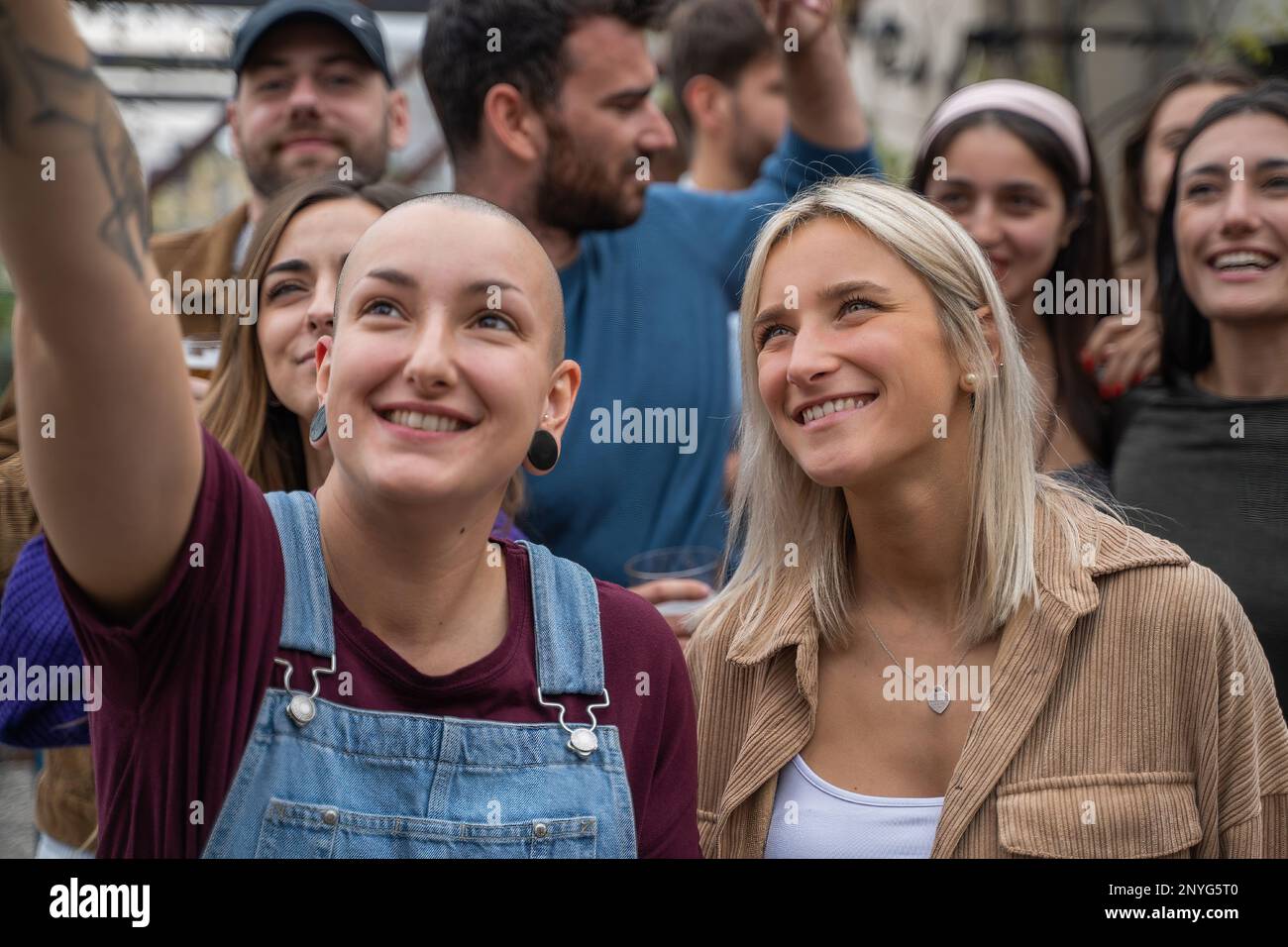 "A diverse group of friends taking a selfie outdoors, at a concert ...