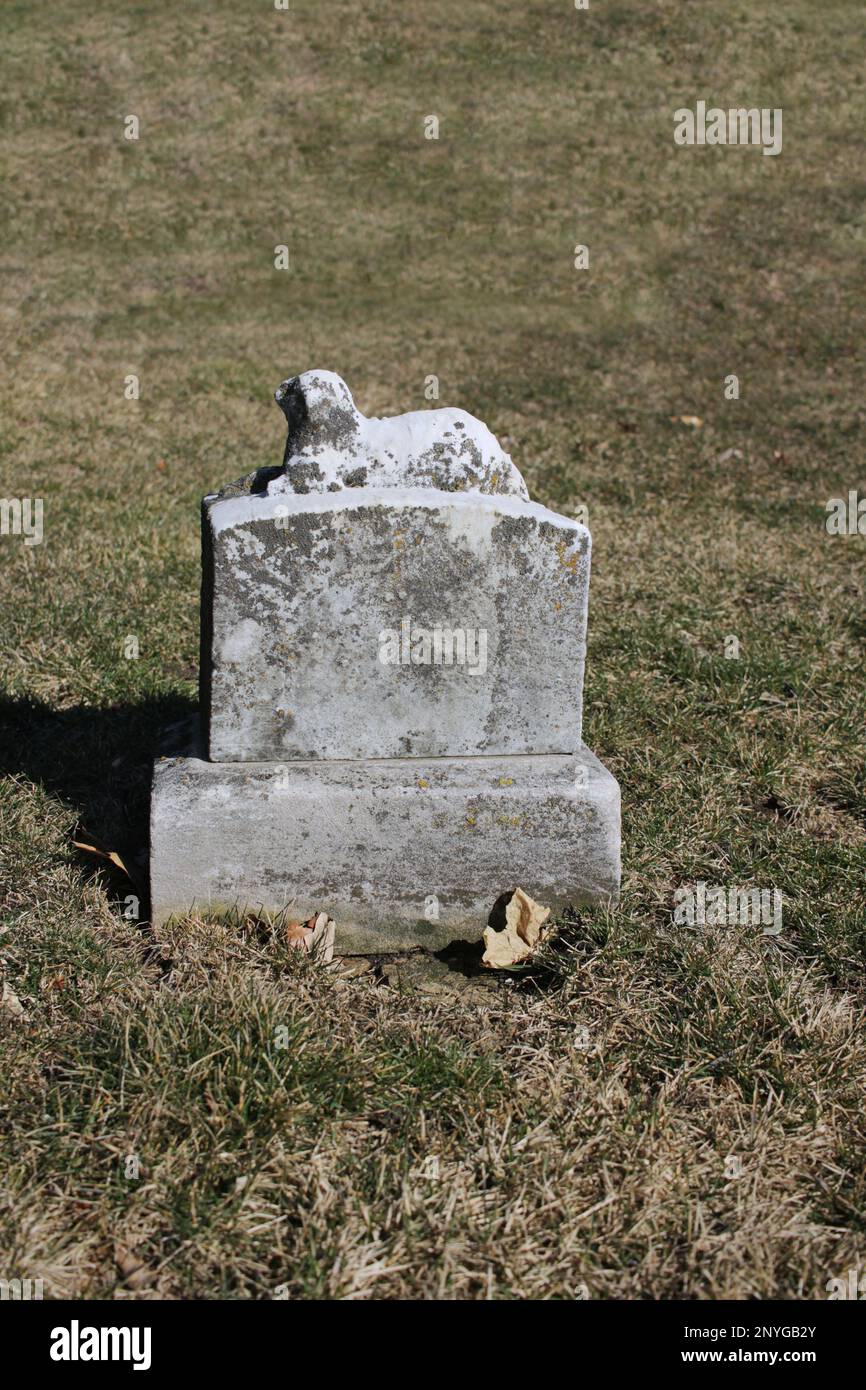 A vintage traditional stone gravestone of a baby's grave with a blank ...