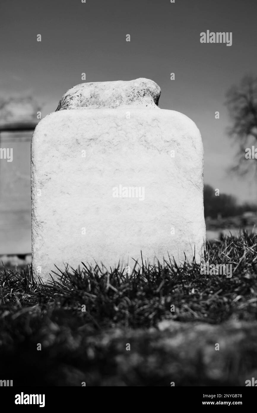 A vintage traditional stone gravestone of a baby's grave with a blank ...