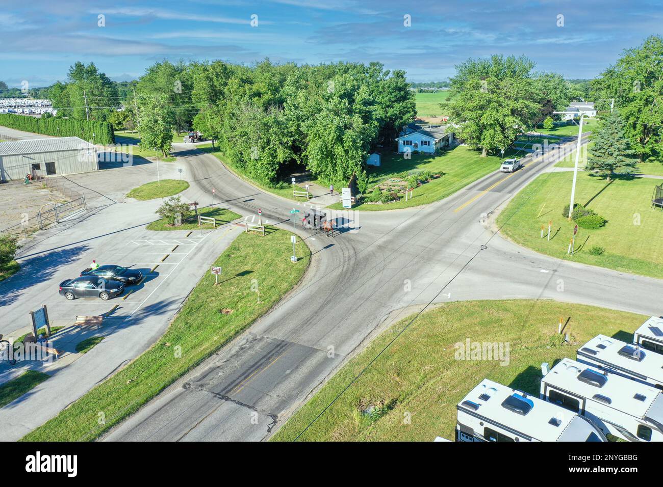 Aerial view of cars and RV park in a rural area surrounded by trees ...