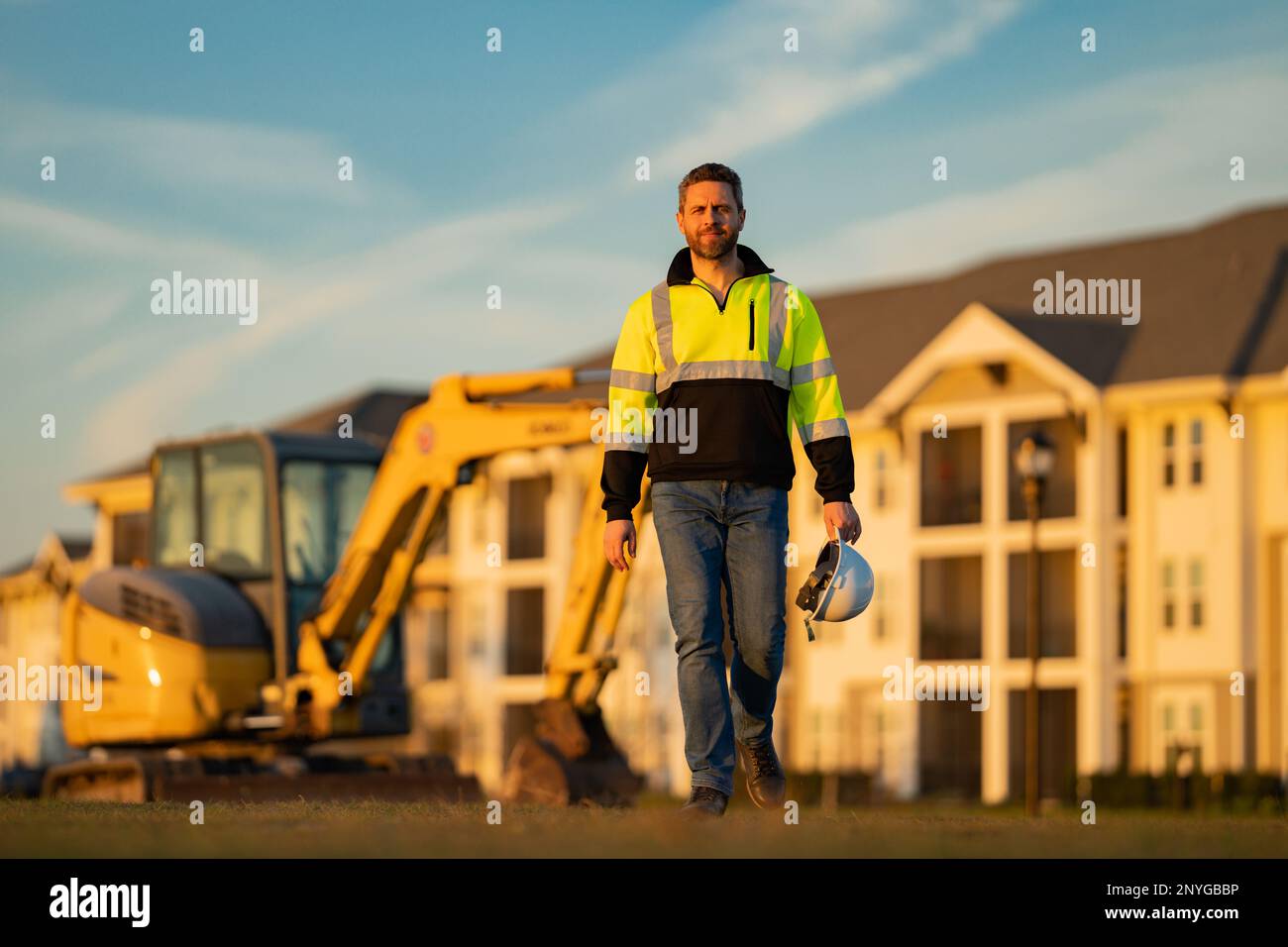 Worker in helmet on site construction. Excavator bulldozer male worker ...