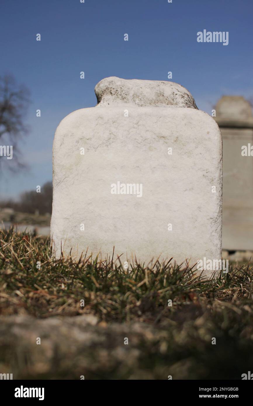A vintage traditional stone gravestone of a baby's grave with a blank ...