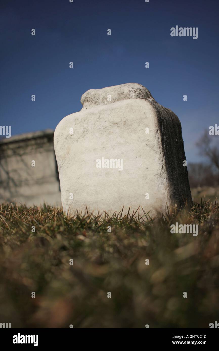 A vintage traditional stone gravestone of a baby's grave with a blank ...