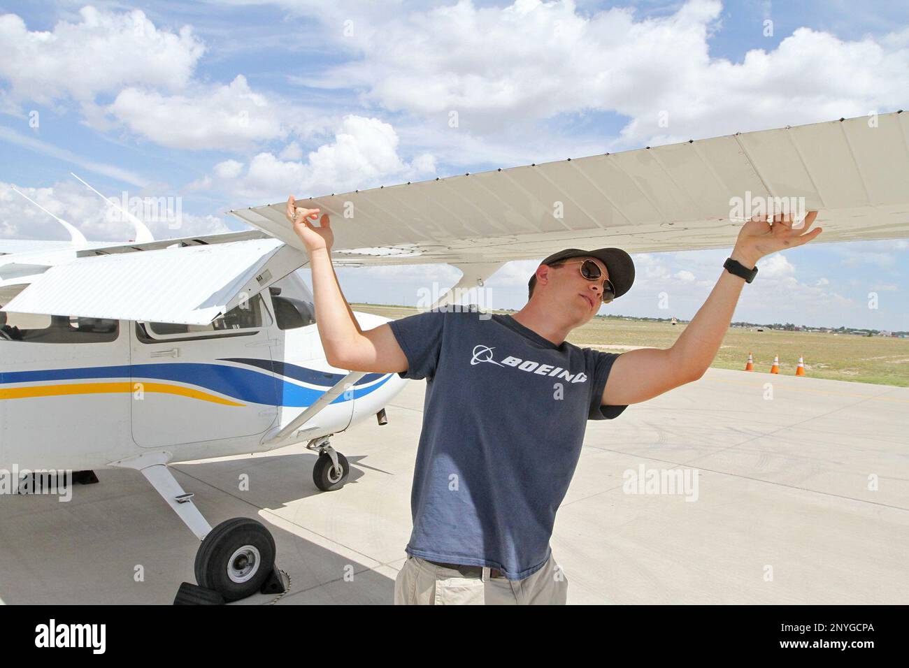 Professional pilot and instructor Miles Turner checks the aileron on a ...