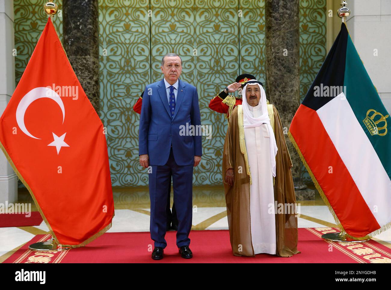 Turkey's President Recep Tayyip Erdogan, left, stands to attention with ...