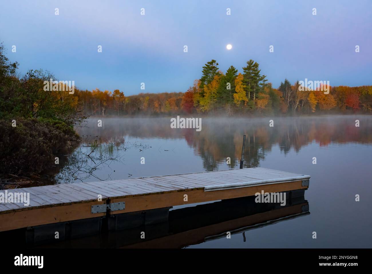An autumn full moon sets at the boat launch on Mineral Lake in the ...