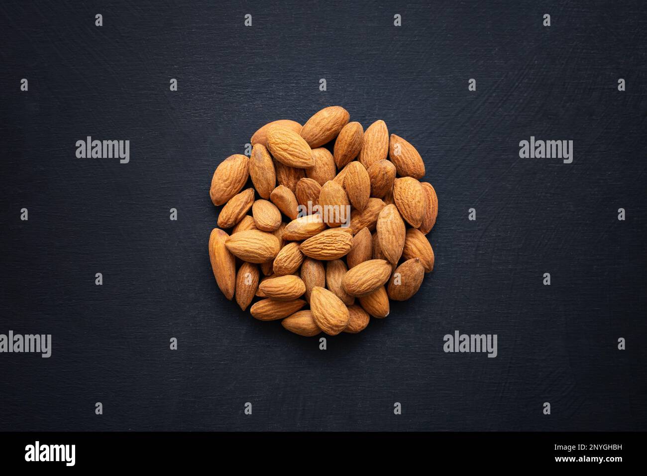 A top view of almonds shaped as a circle on a black background Stock ...