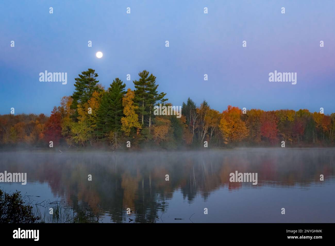 An autumn full moon sets at the boat launch on Mineral Lake in the ...