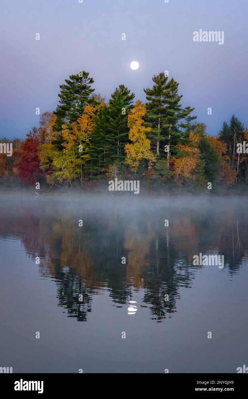 An autumn full moon sets at the boat launch on Mineral Lake in the ...