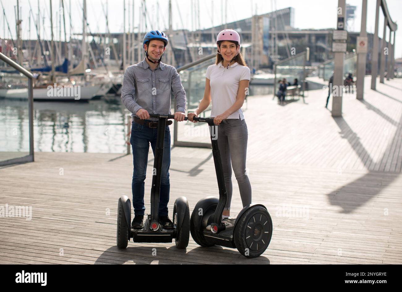 young couple guy and girl are walking on the segway along the board ...