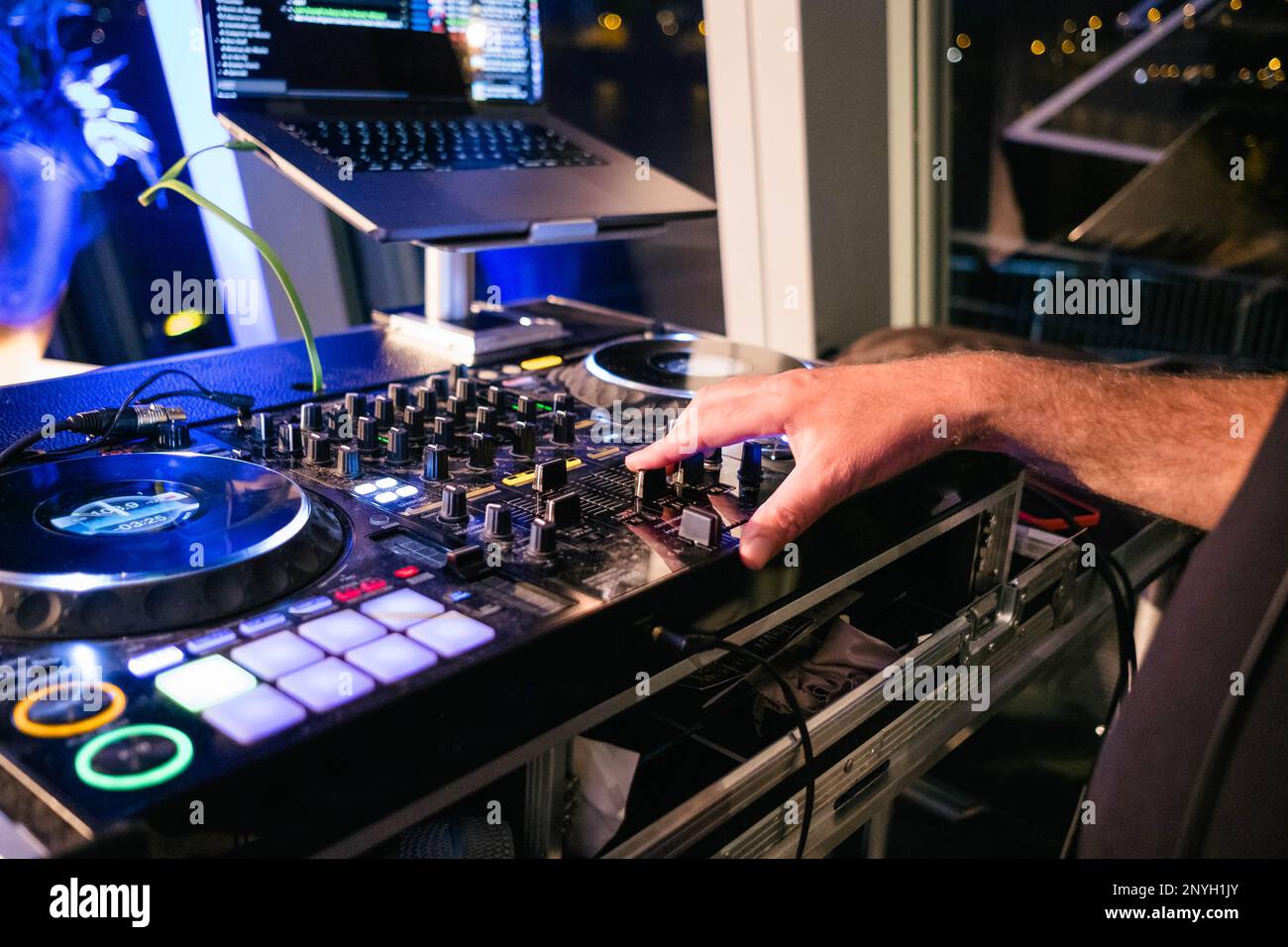 A DJ scratches with his fingers on the DJ booth. His hand is on the ...