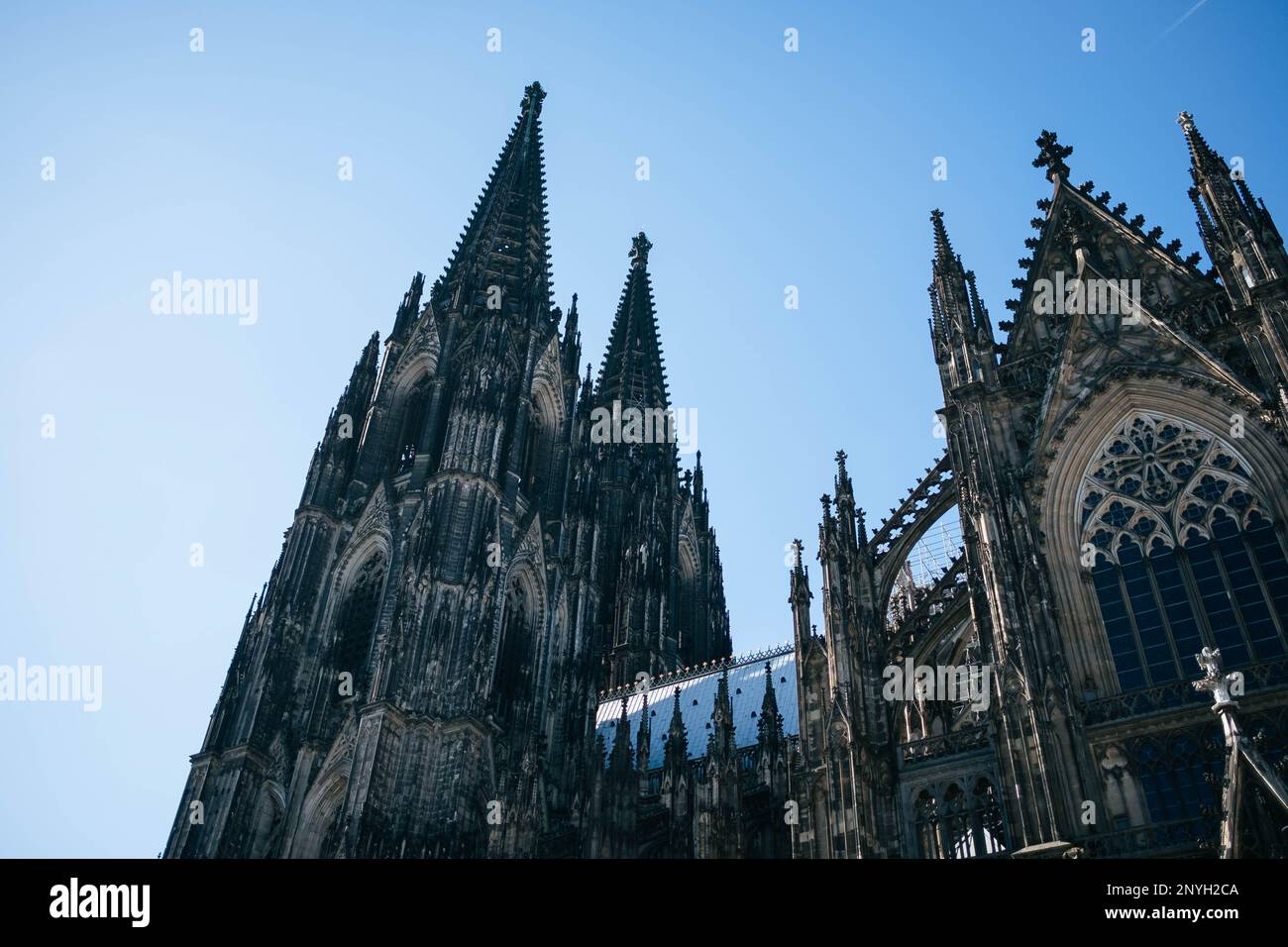 A close-up of Cologne Cathedral from below under a blue sky. The ...