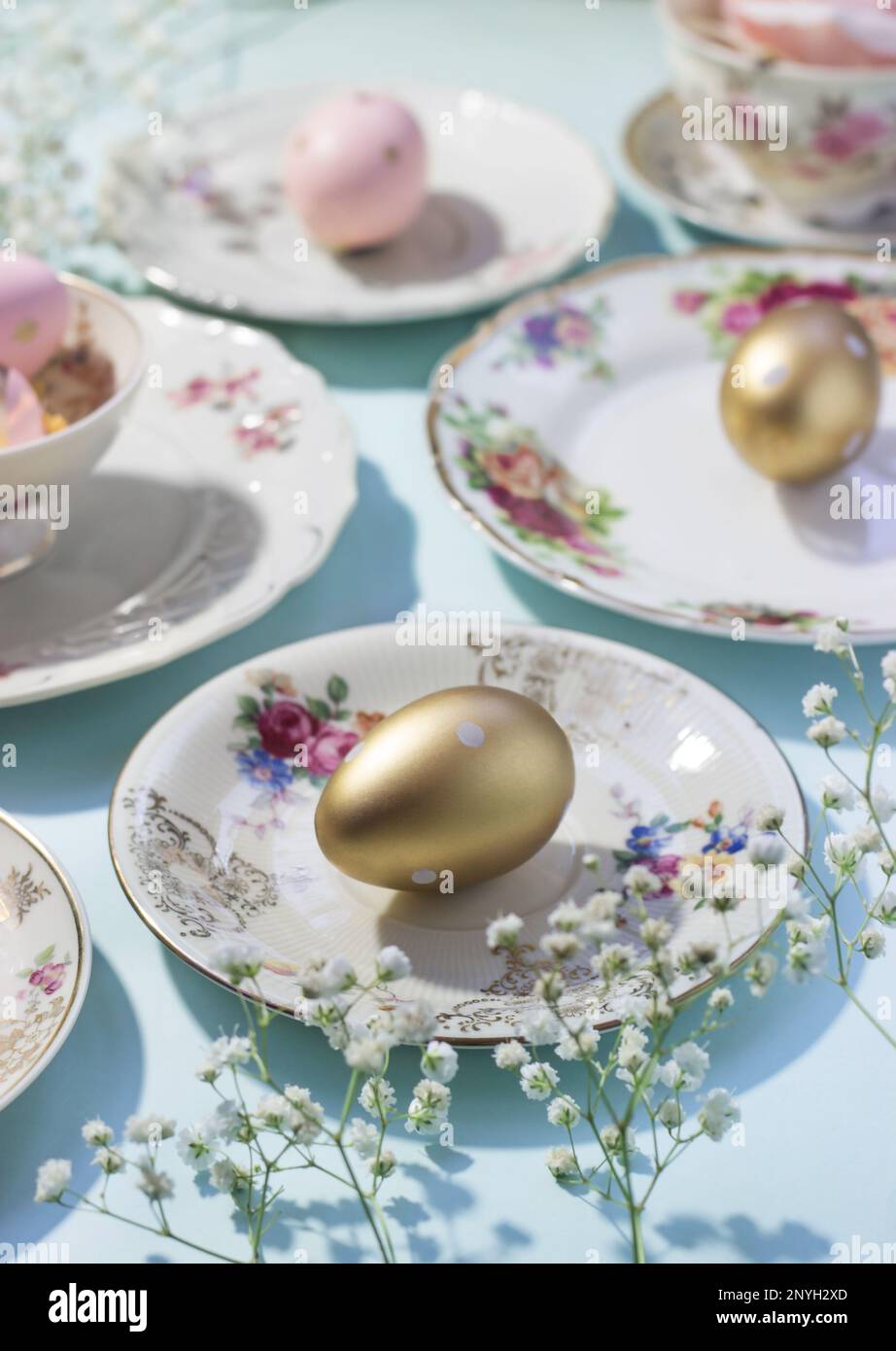 Aesthetic Easter composition made of colorful plates and golden eggs ...