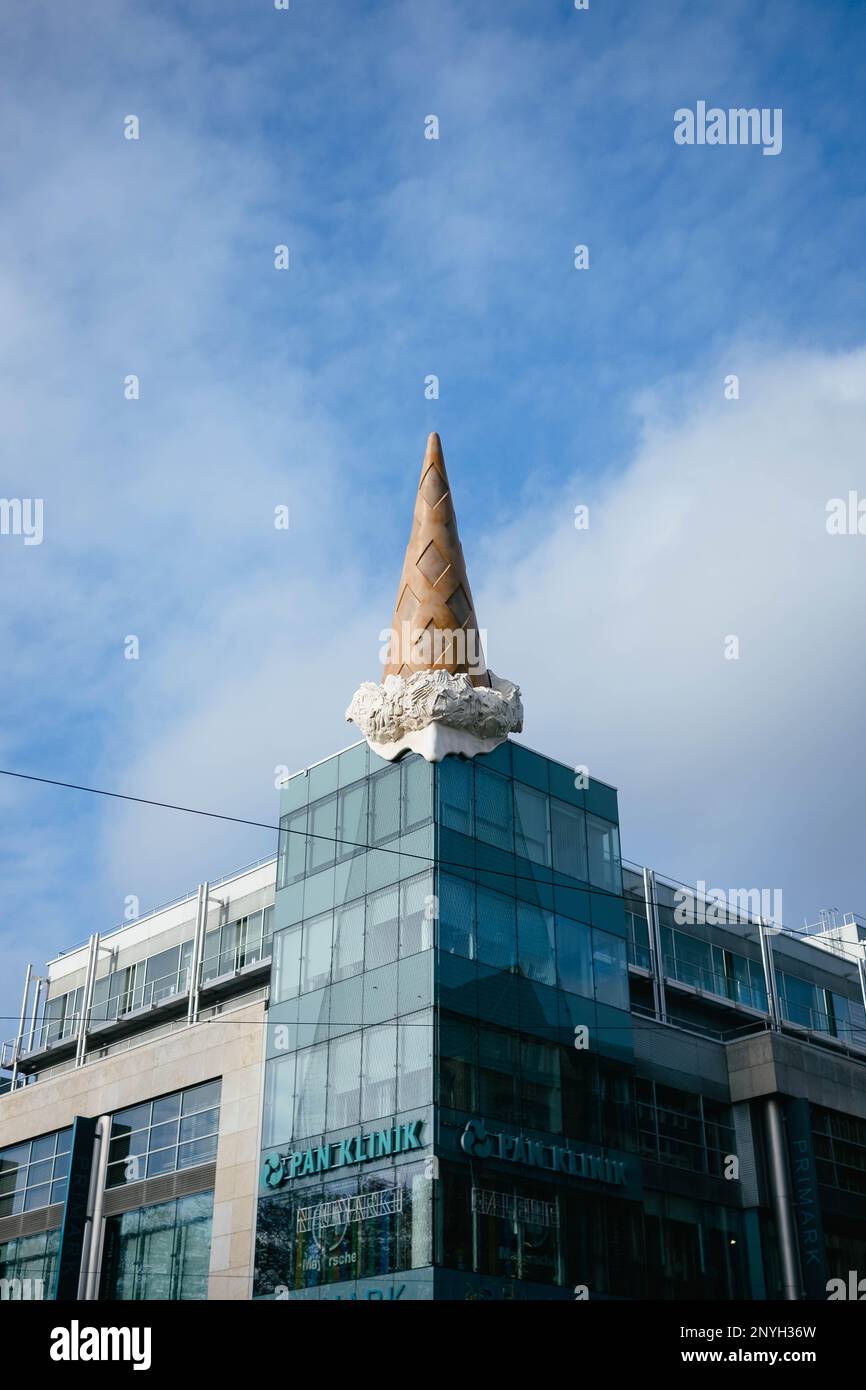 Vertical shot of a giant ice cream cone on a glass building. The scoop ...