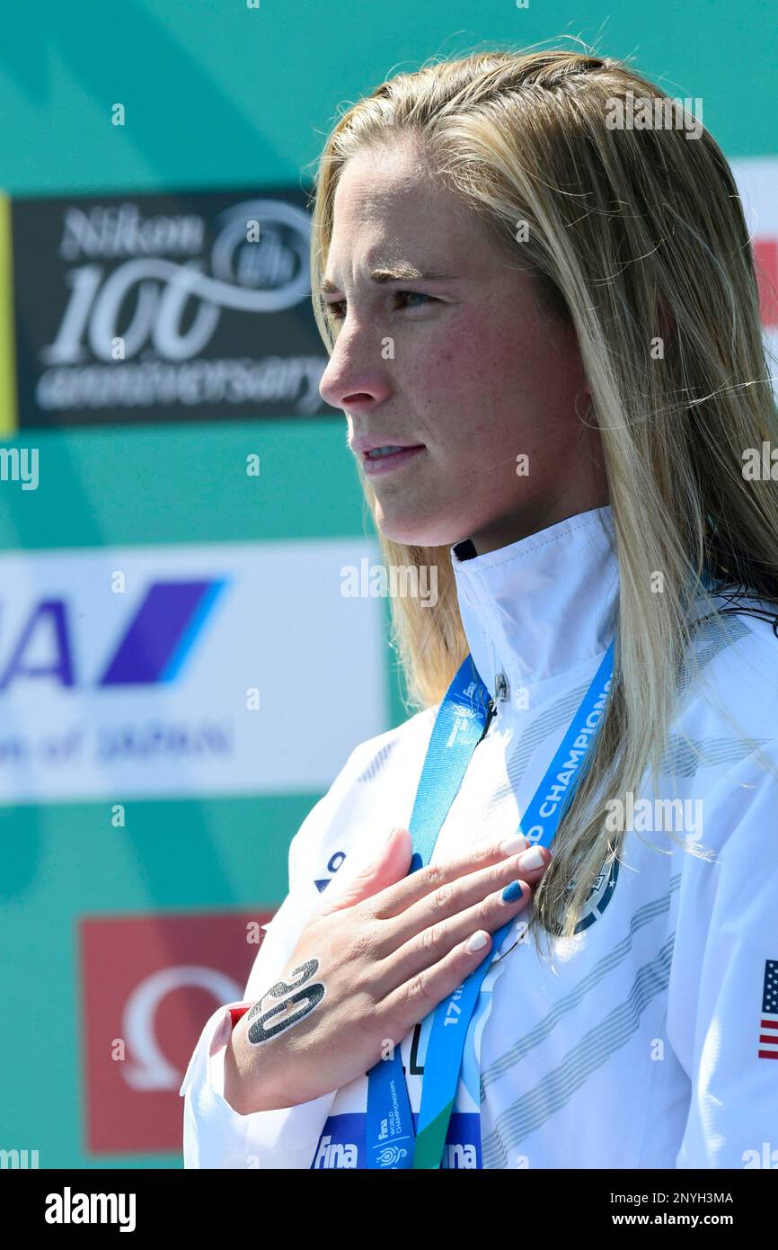 First placed Ashley Twichell, of the US, listens to the national anthem ...