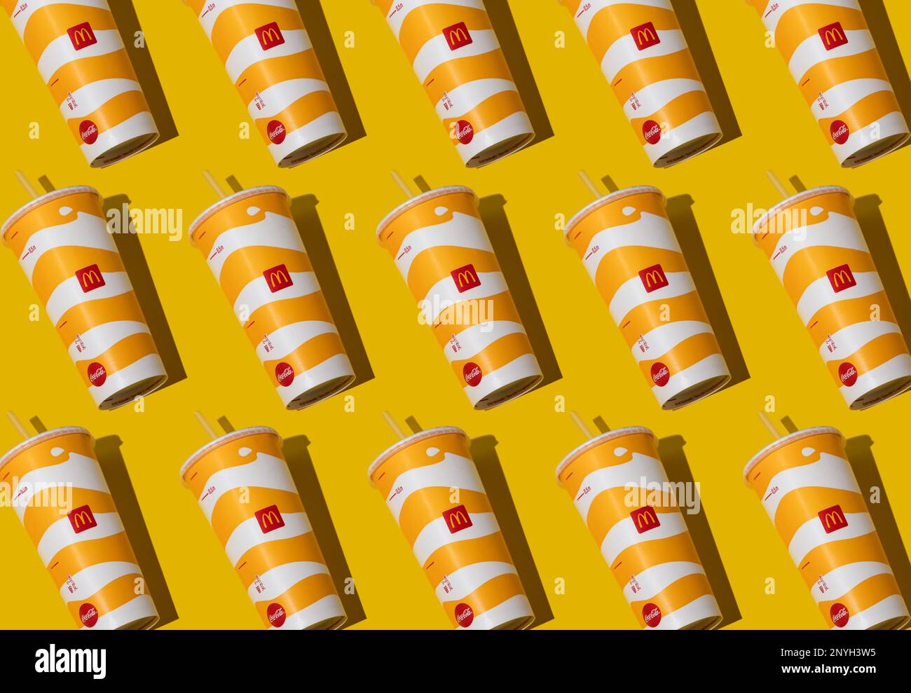 Yellow glass of McDonald's pattern. Paper cup with lid. Takeaway drink ...