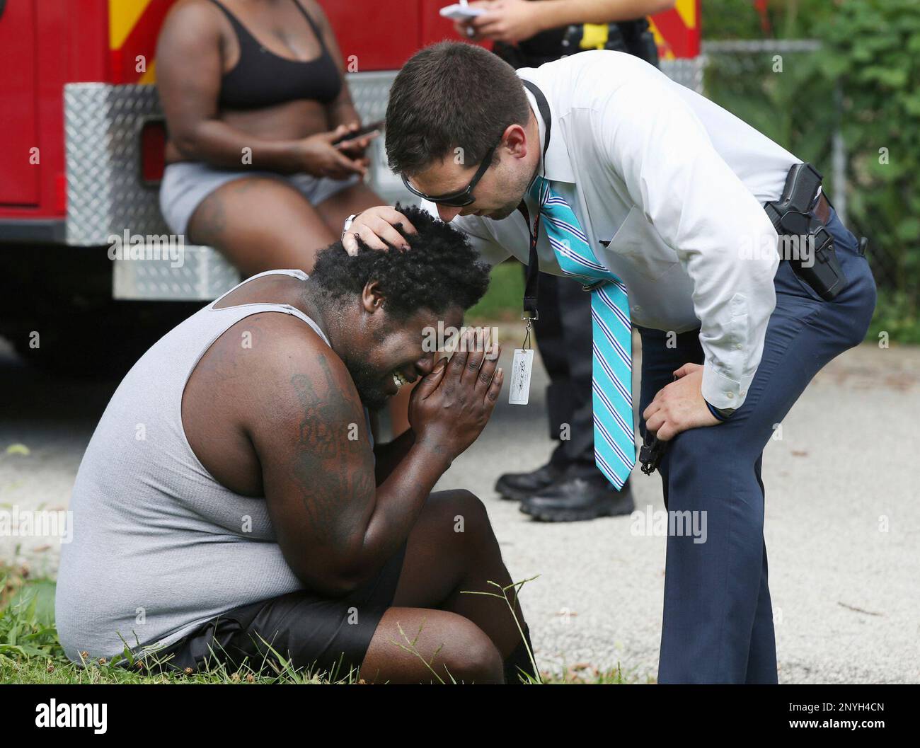 Alton, Ill., Police Detective PJ Bennett comforts a family member as ...