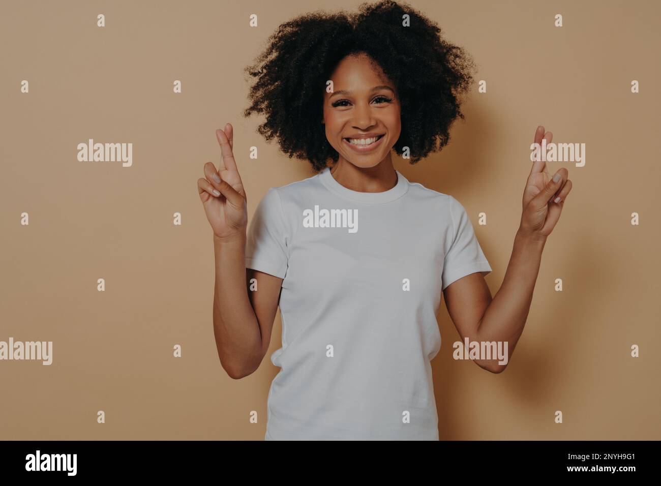 Young hopeful african american female isolated on beige studio ...