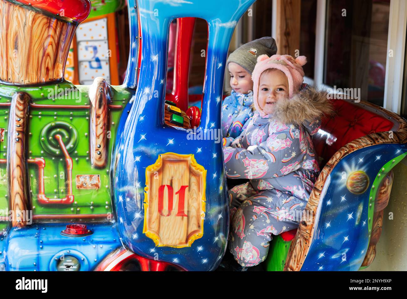 Two sisters in train carousel in amusement park Stock Photo - Alamy