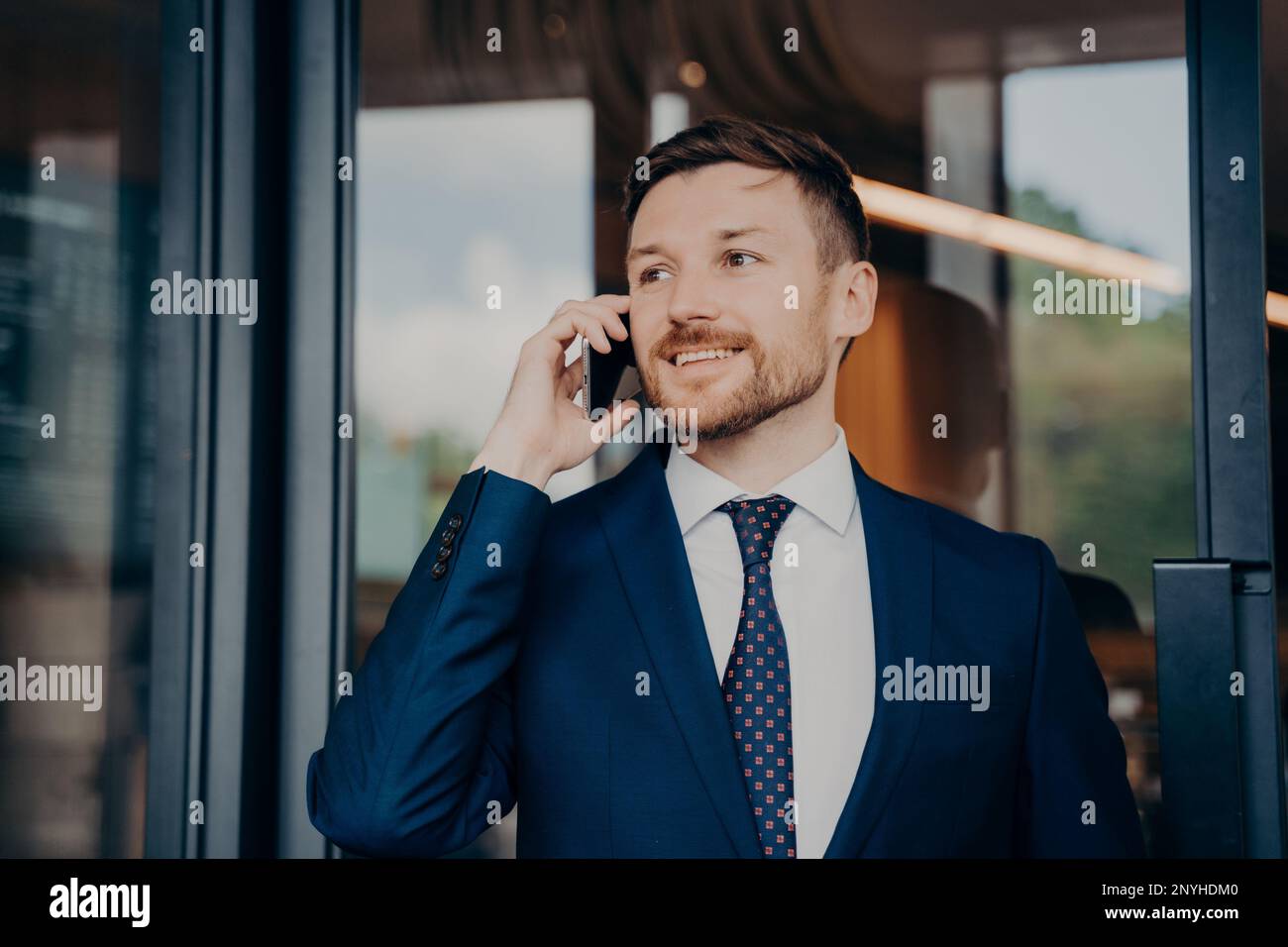 Happy male business owner in blue suit receiving good news about ...