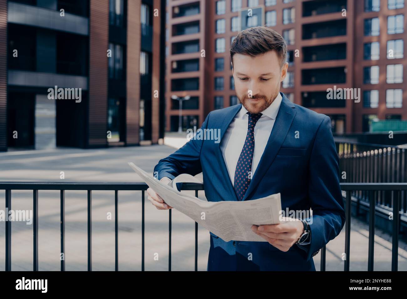 Focused businessperson dressed in suit checking latest newspaper for ...