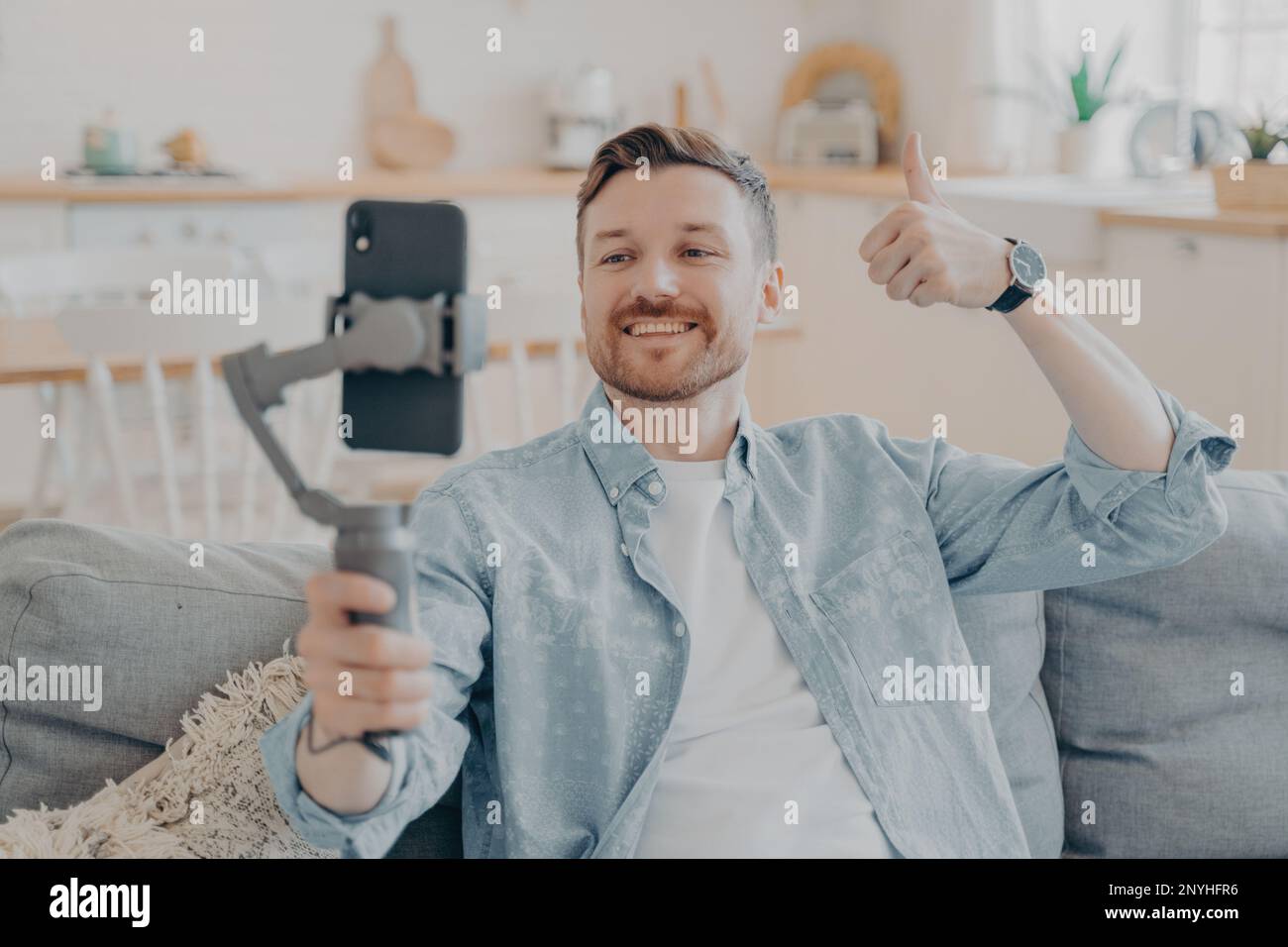 Young man in video call expressing his satisfaction, holding gimbal ...