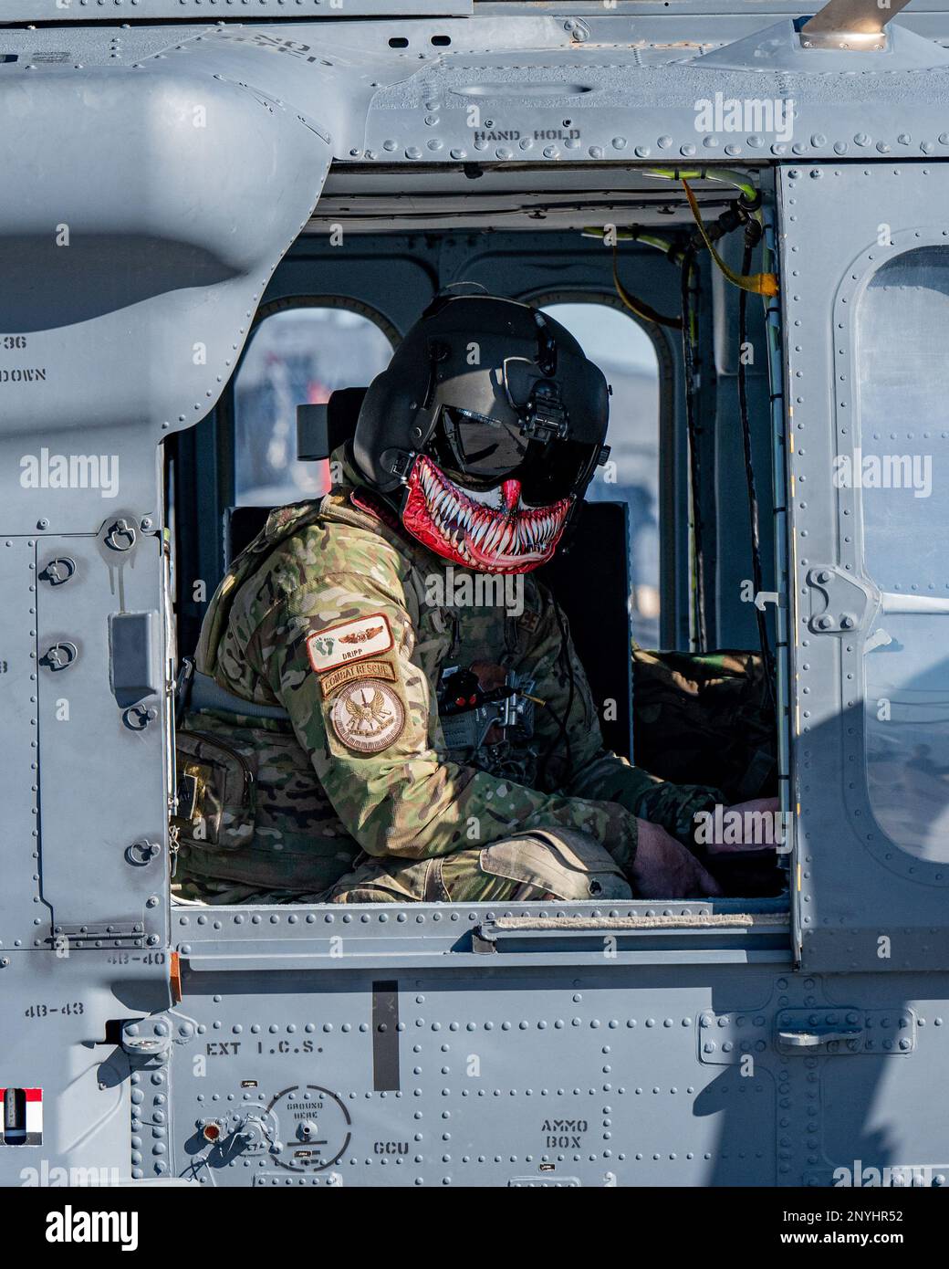 A U.S. Air Force Airman rests before take-off on an HH-60W Jolly Green ...