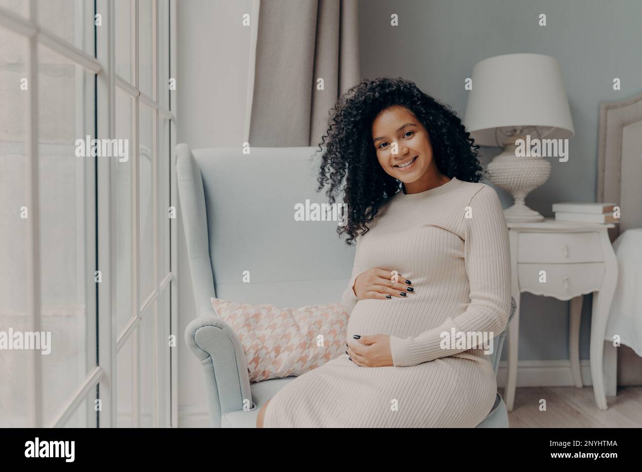 Happy young pregnant afro american lady in dress preparing soon to be ...
