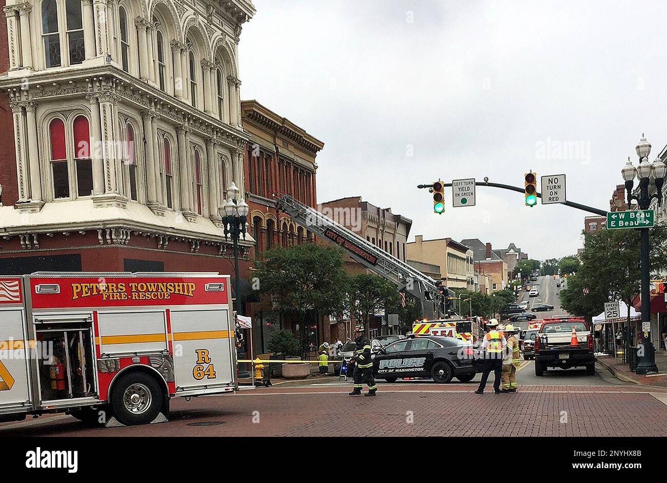 Emergency workers block off the street as they examine the front of an ...
