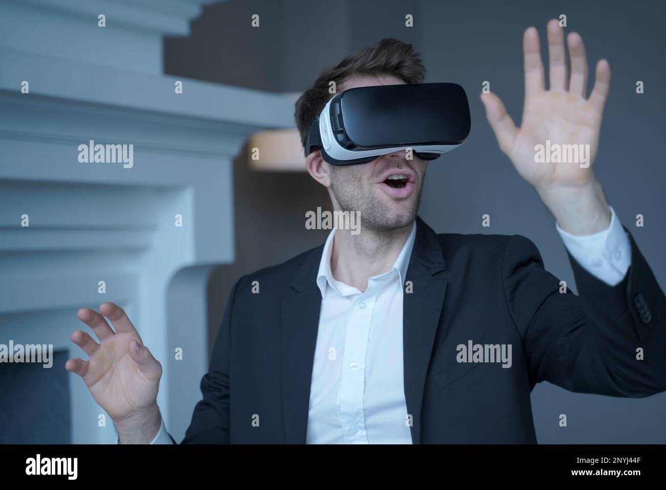 Man entrepreneur in formal suit sitting at home office while testing VR ...