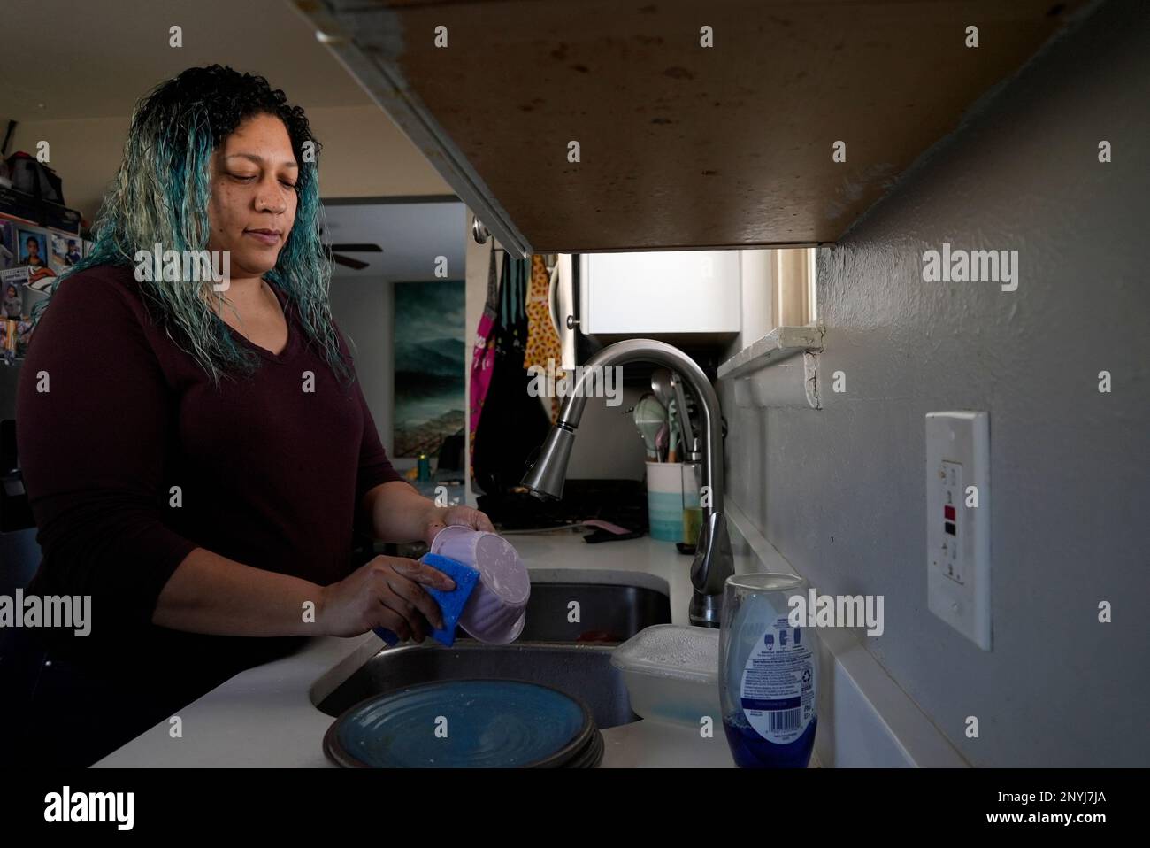 Betty Rivas cleans dishes using tap water Thursday, Feb. 23, 2023, in ...