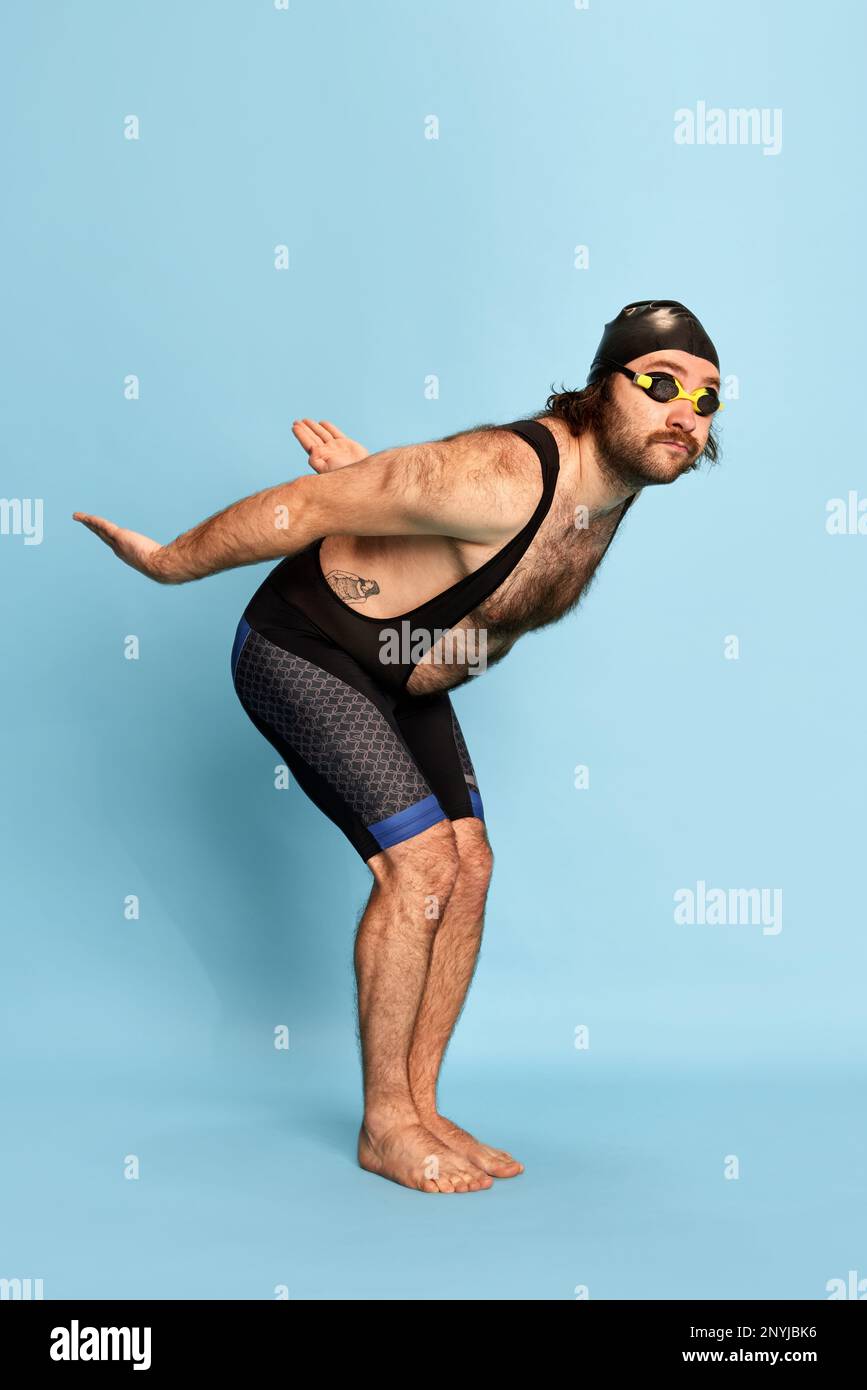 Comic portrait of funny bearded man in swimsuit and swimming cap and ...