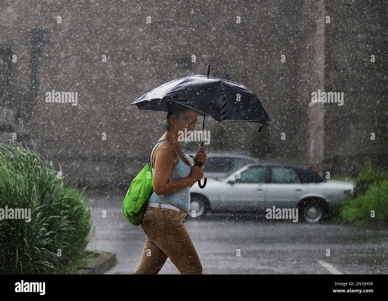 A pedestrian walks in a deluge of heavy rain on Friday, July 7, 2017 ...